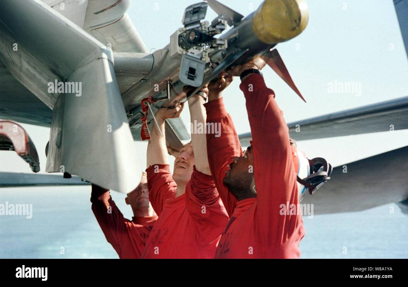 Aviation ordnancemen load an F-14 Tomcat with an AIM-9 Sidewinder ...