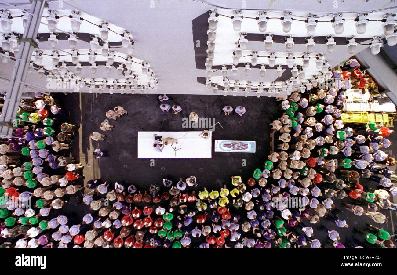 A rainbow of sailors in colored flight deck jerseys and uniform shirts ...