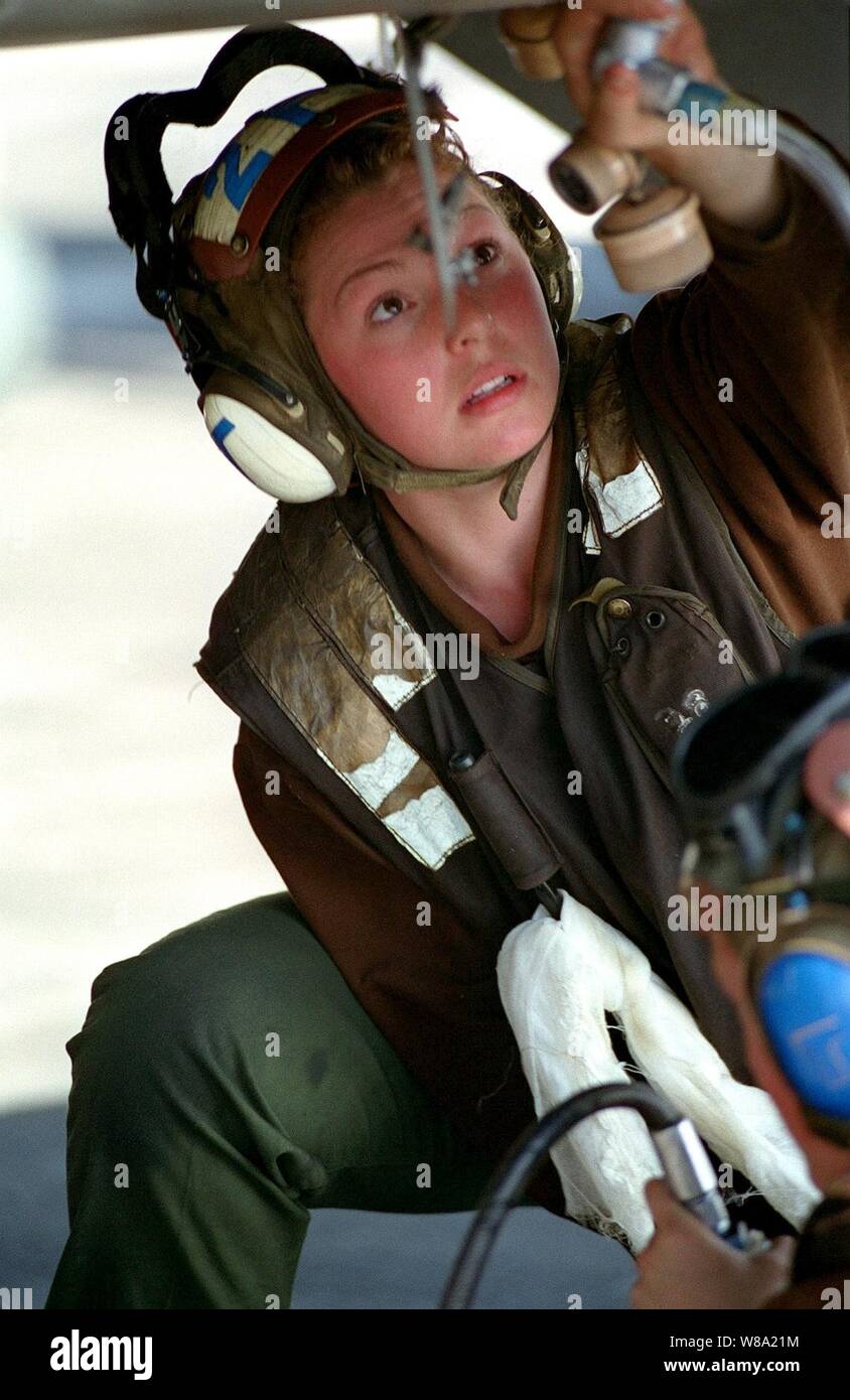 U.S. Navy Airman Shannon Ireland performs maintenance on an F/A-18 ...