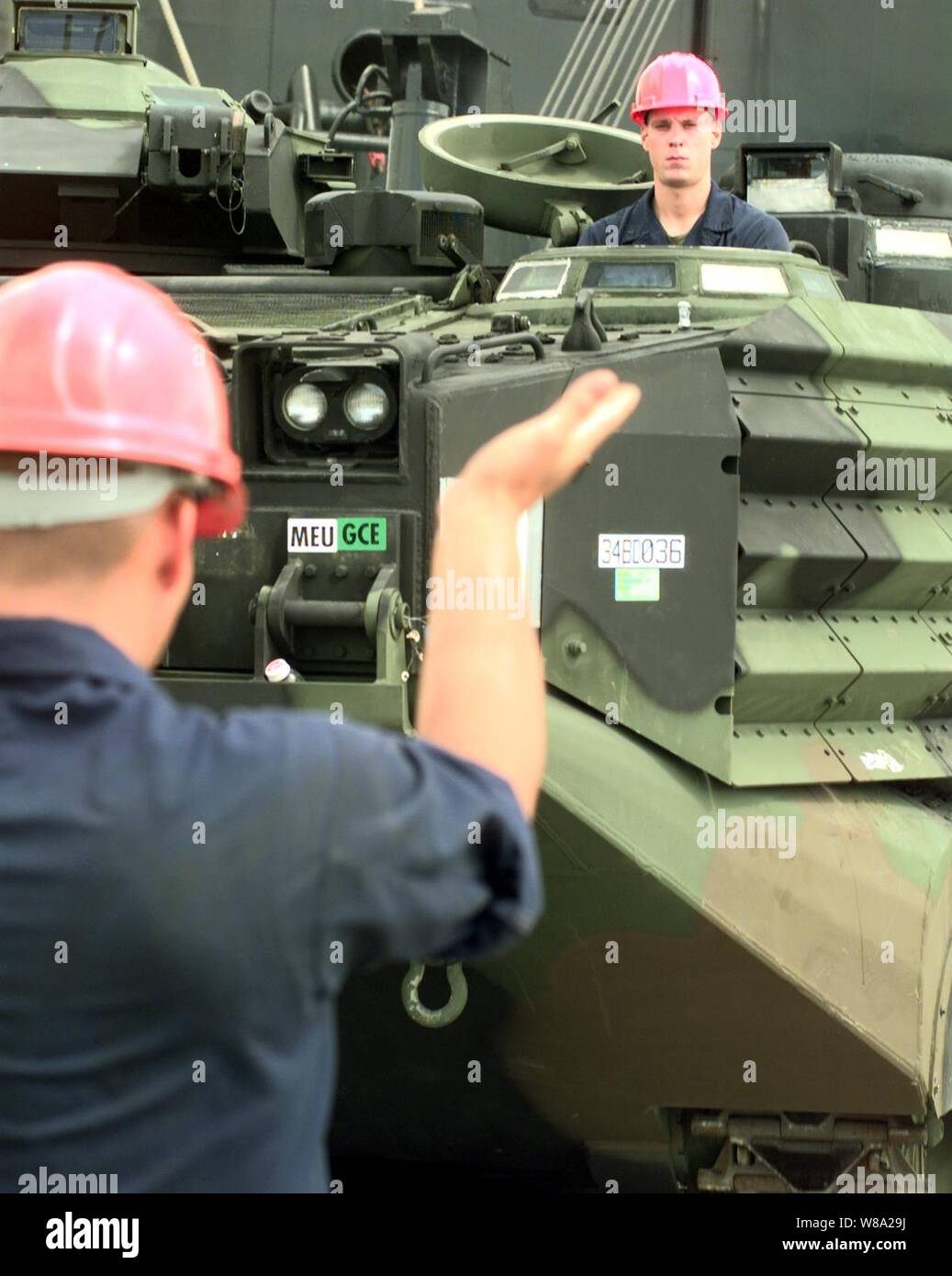The driver of a U.S. Marine Corps Amphibious Assault Vehicle is guided ...