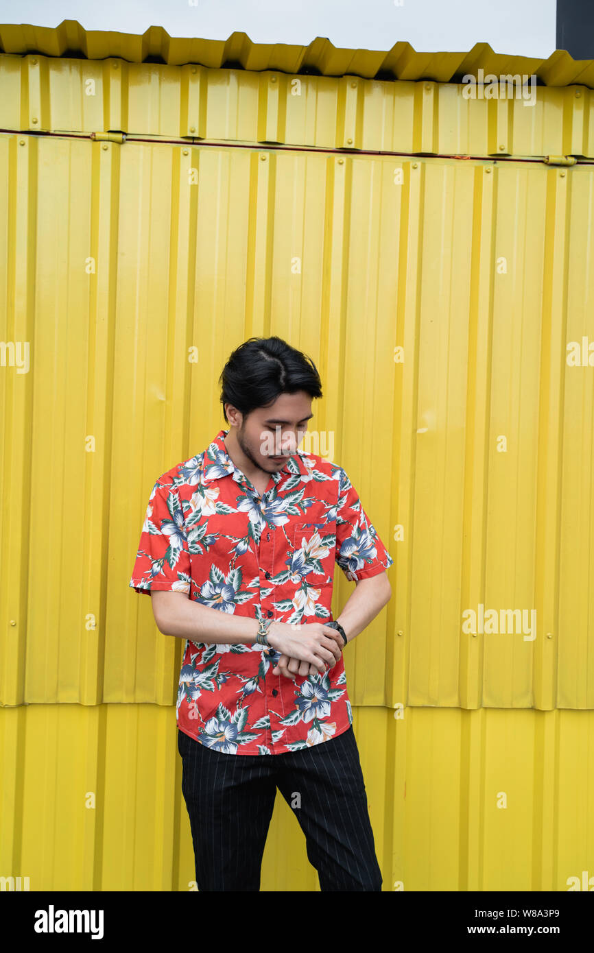 Young man standing front yellow background Stock Photo - Alamy