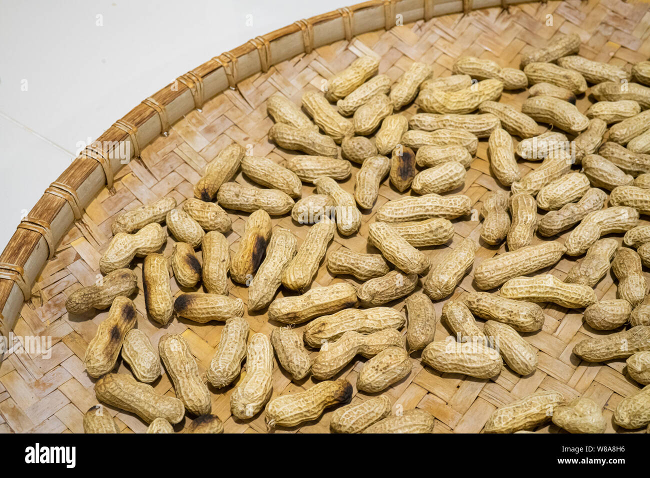 Dried cooked peanuts seen on a bamboo tray Stock Photo - Alamy
