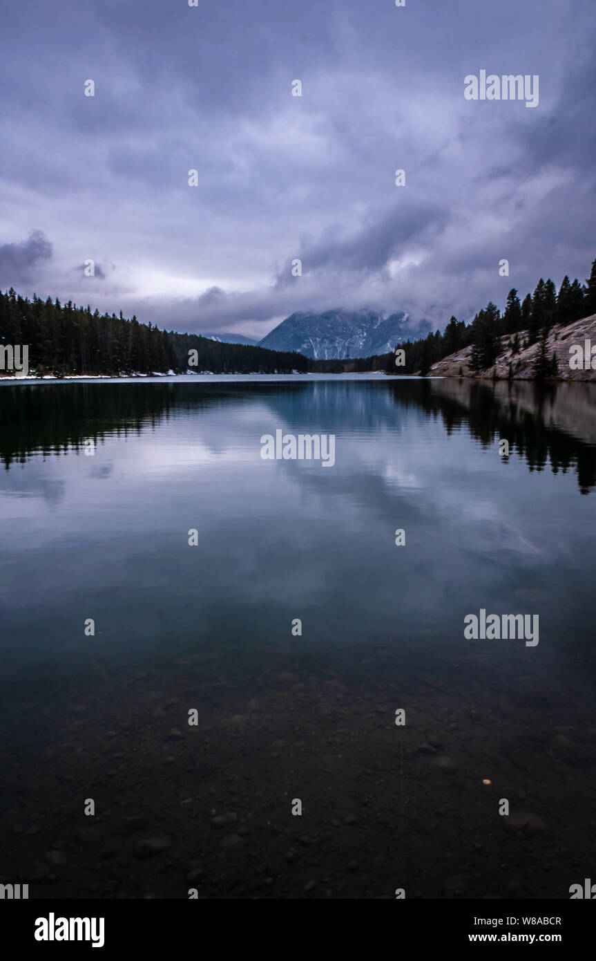 Wintry reflections at Johnson Lake in Banff National Park in Alberta ...