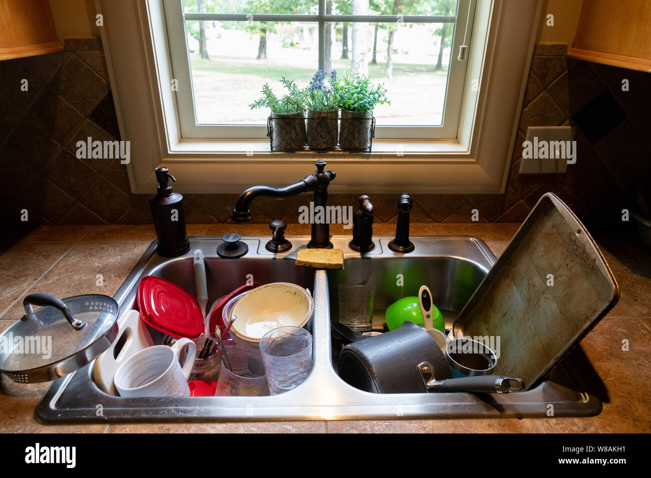 Stack of dirty dishes piled into the kitchen sink Stock Photo - Alamy