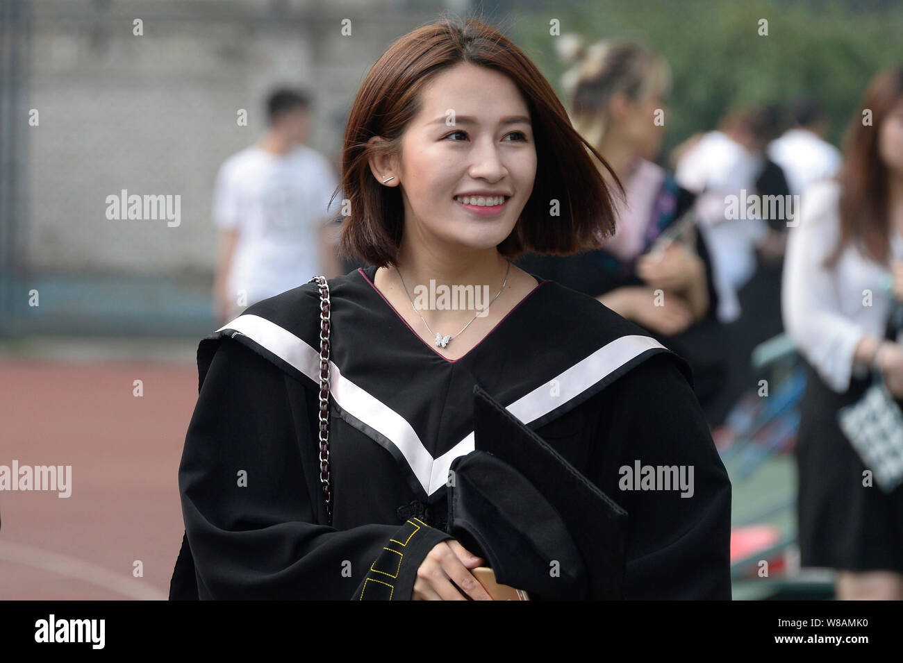 A Chinese graduate dressed in an academic gown arrives at a graduation ...