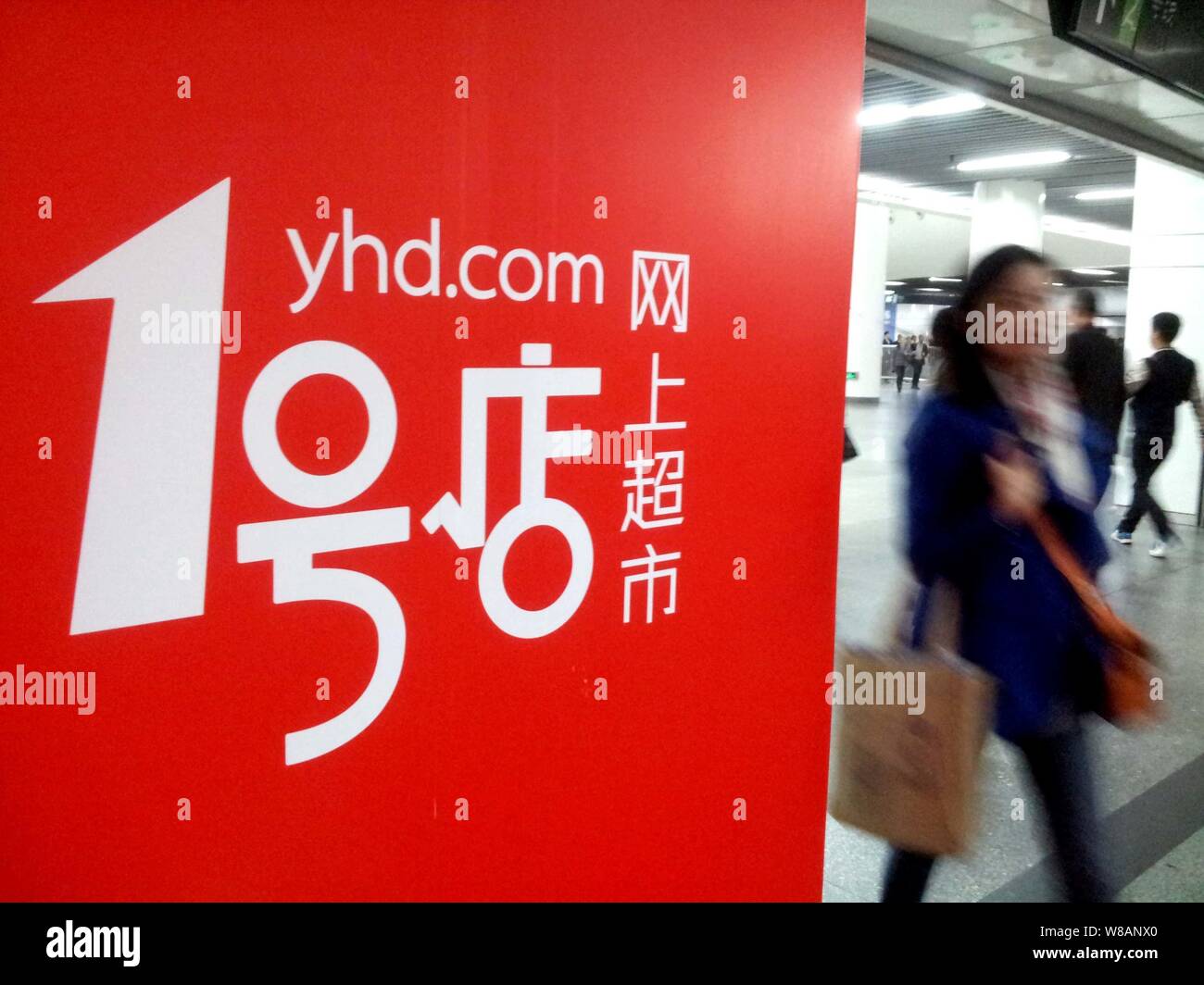 --FILE--Passengers walk past an advertisement of Chinese online ...
