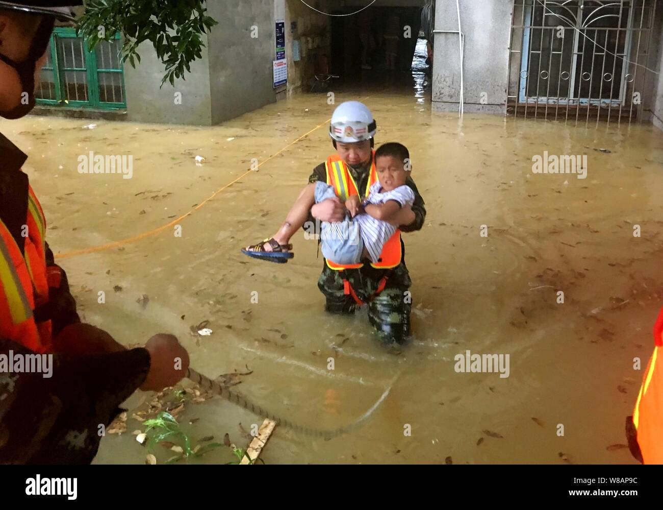 A Chinese rescuer evacuates a young boy from a residential building ...
