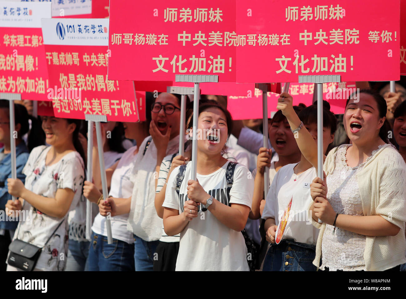 Younger Chinese students hold up placards or banners to show support ...