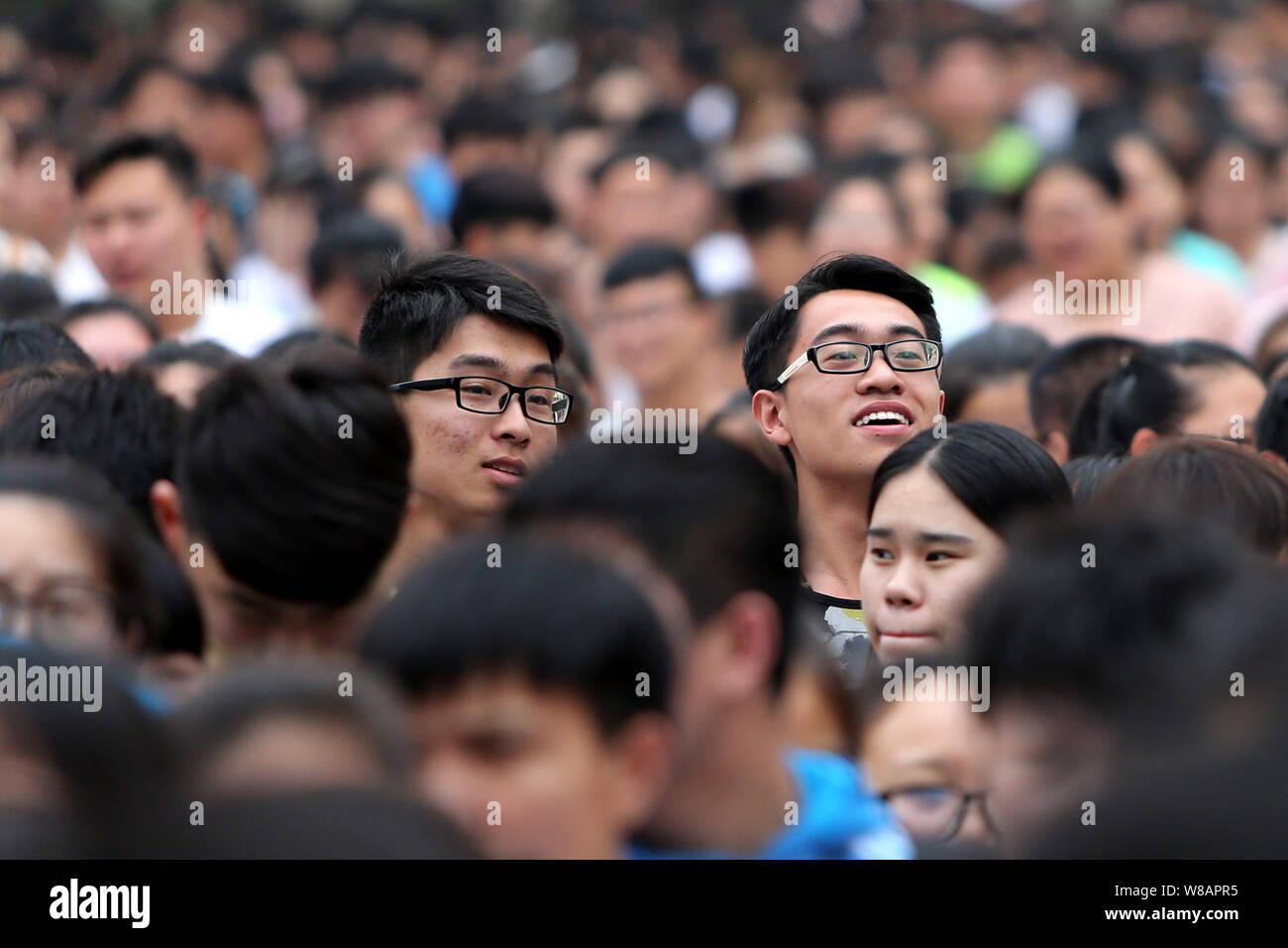 A crowd of Chinese students exit from a school after finishing an ...