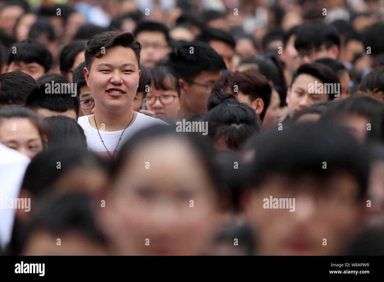 A crowd of Chinese students exit from a school after finishing an ...