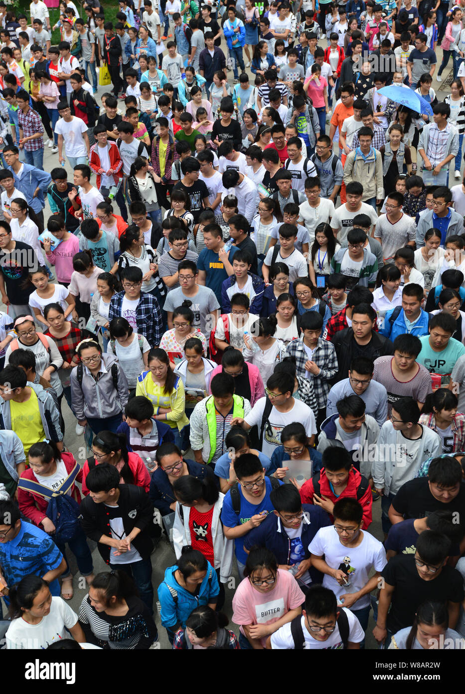 A crowd of Chinese students exit from a school after finishing an ...