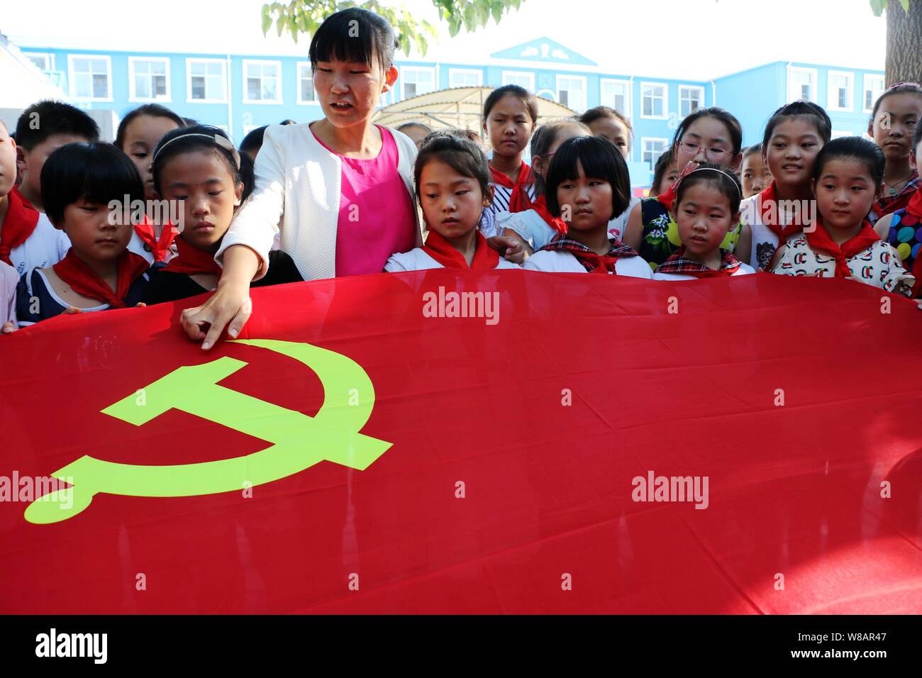 A Chinese teacher explains details of the flag of the Communist Party ...