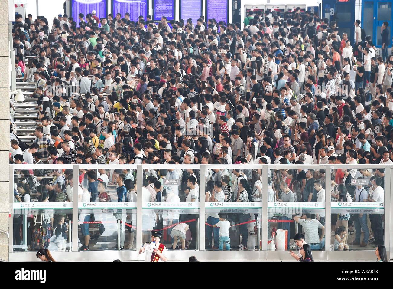 A crowd of Chinese passengers queue up to check in at the Shijiazhuang ...