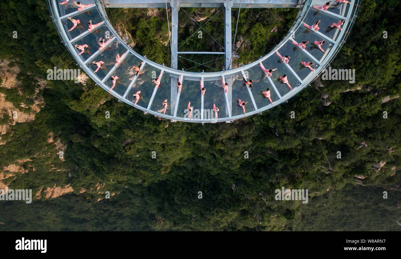 Aerial view of Chinese enthusiasts performing yoga on the glass ...