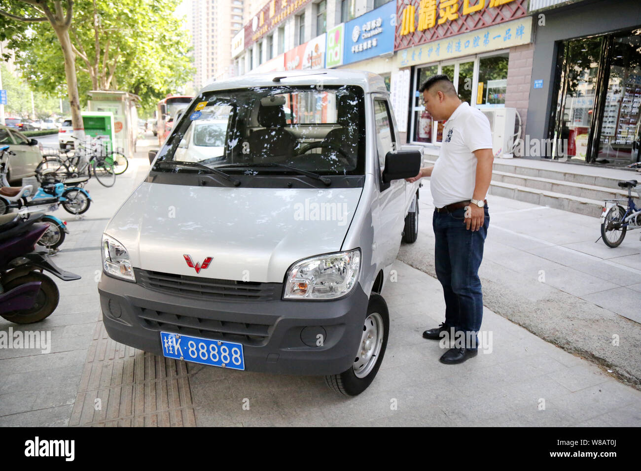 Chinese driver Mr. Zhou looks at his SGMW Wuling Sunshine pickup with ...