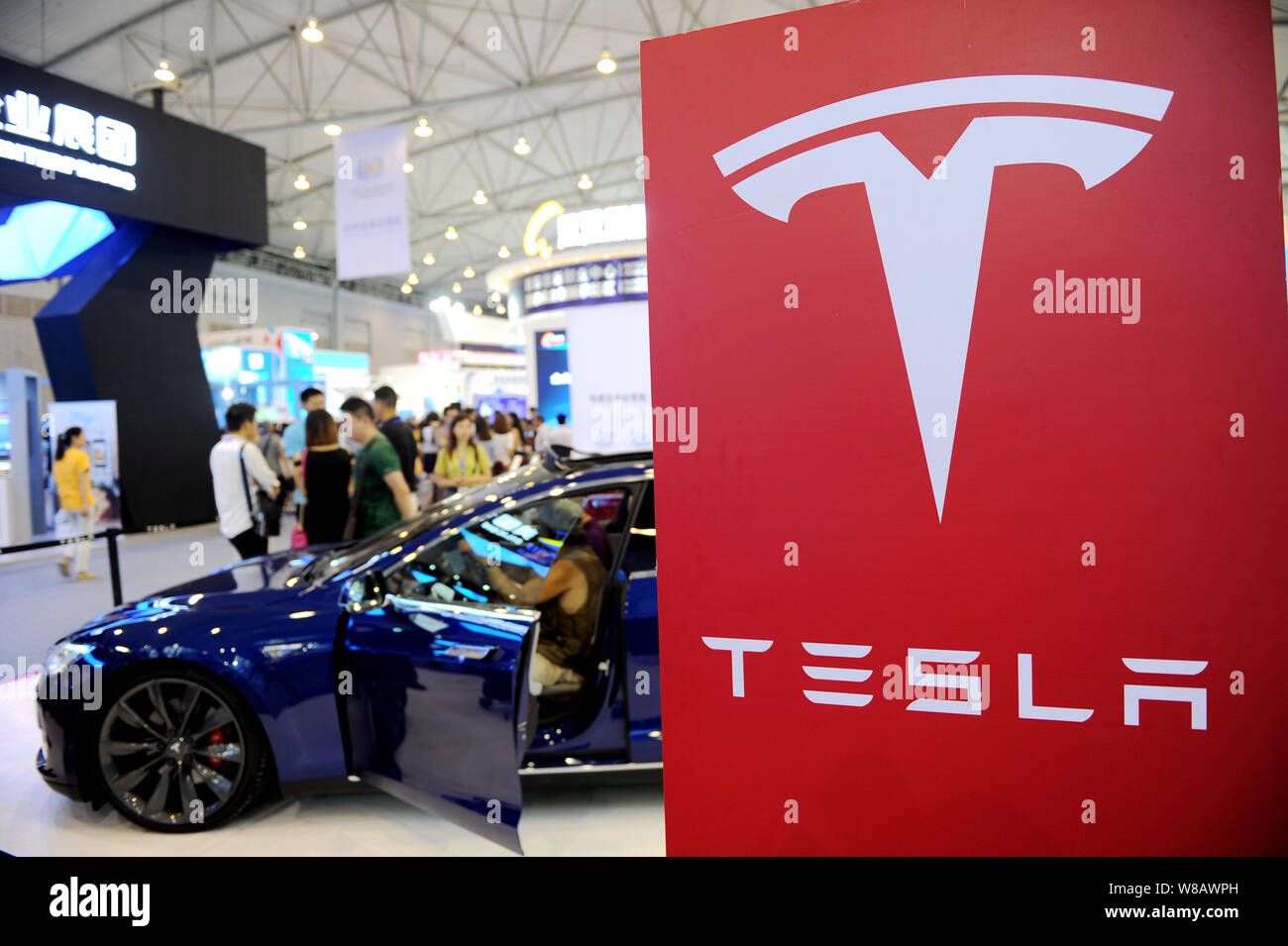 People visit the stand of Tesla during an exhibition in Chengdu city ...