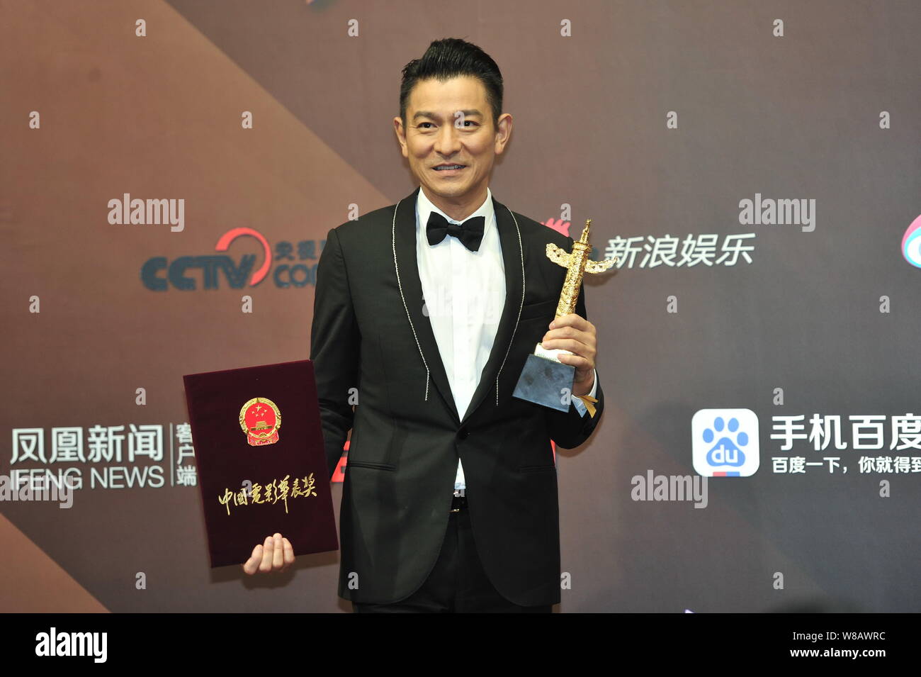 Hong Kong singer and actor Andy Lau poses with his trophy during the ...