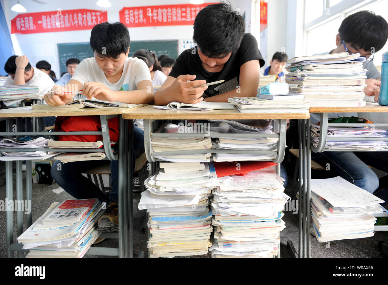 Chinese students review textbooks or write test papers to prepare for ...