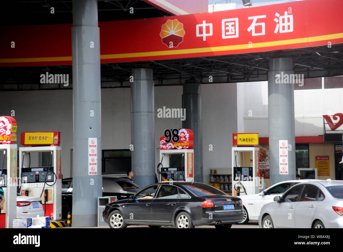 --FILE--Chinese drivers line up their cars to be refuelled at a gas ...