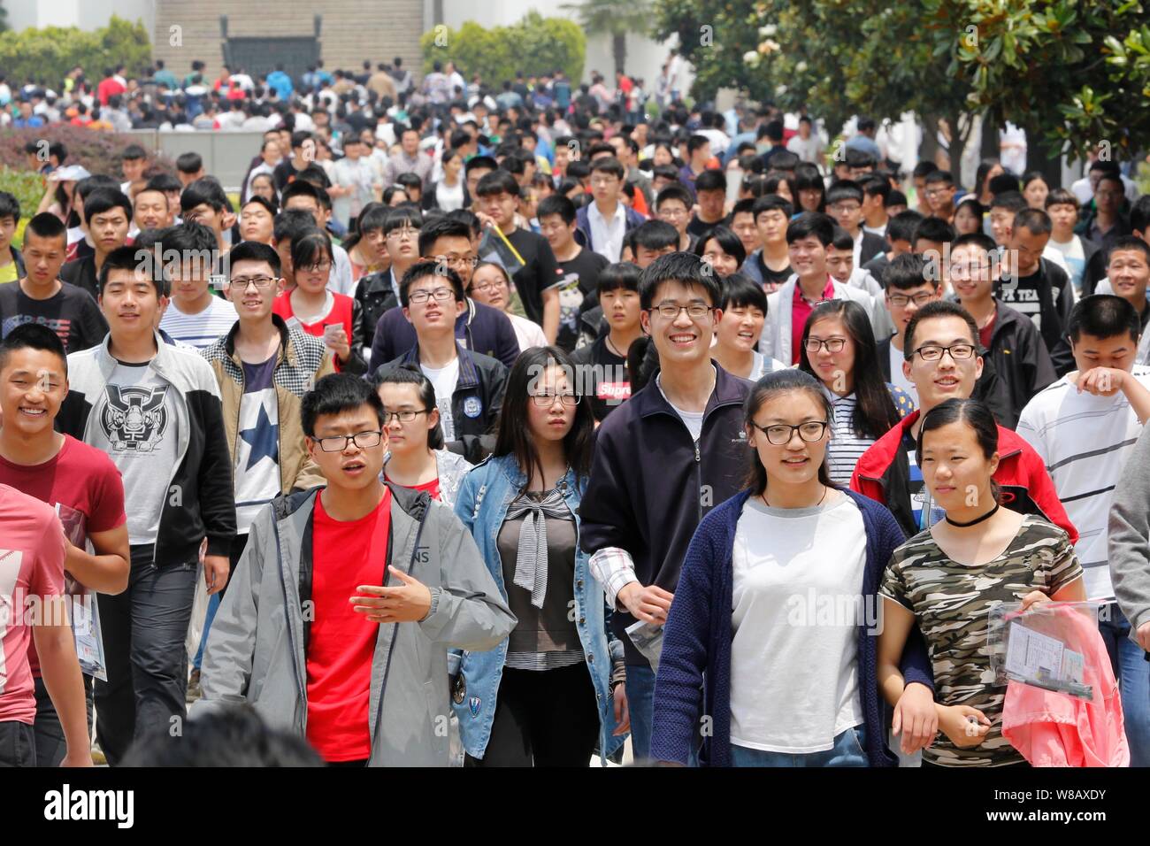 A crowd of Chinese students exit from a school after finishing an ...