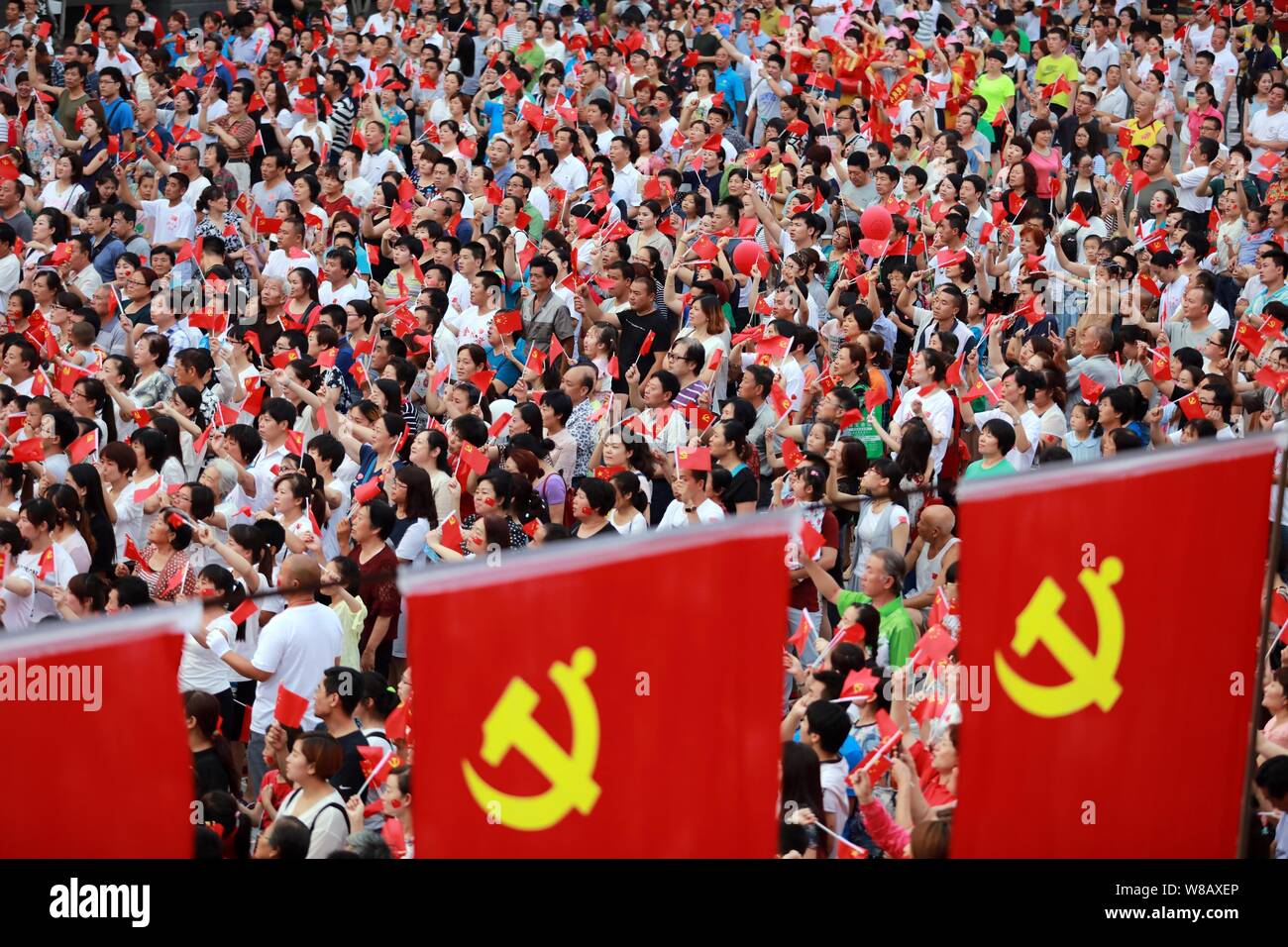 Local Chinese residents wave flags of China and the Communist Party of ...