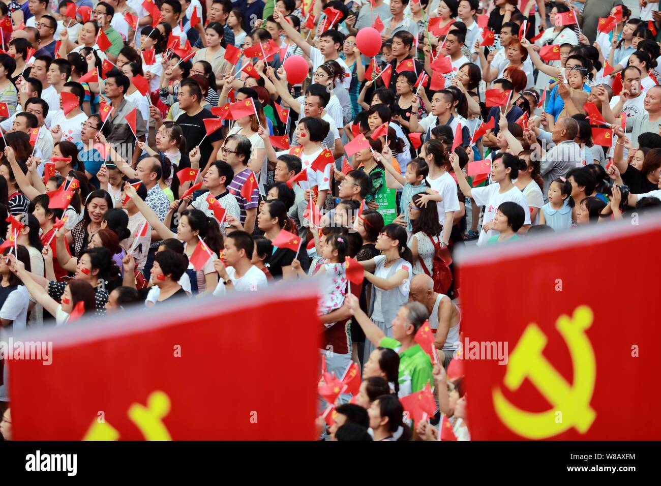 Local Chinese residents wave flags of China and the Communist Party of ...