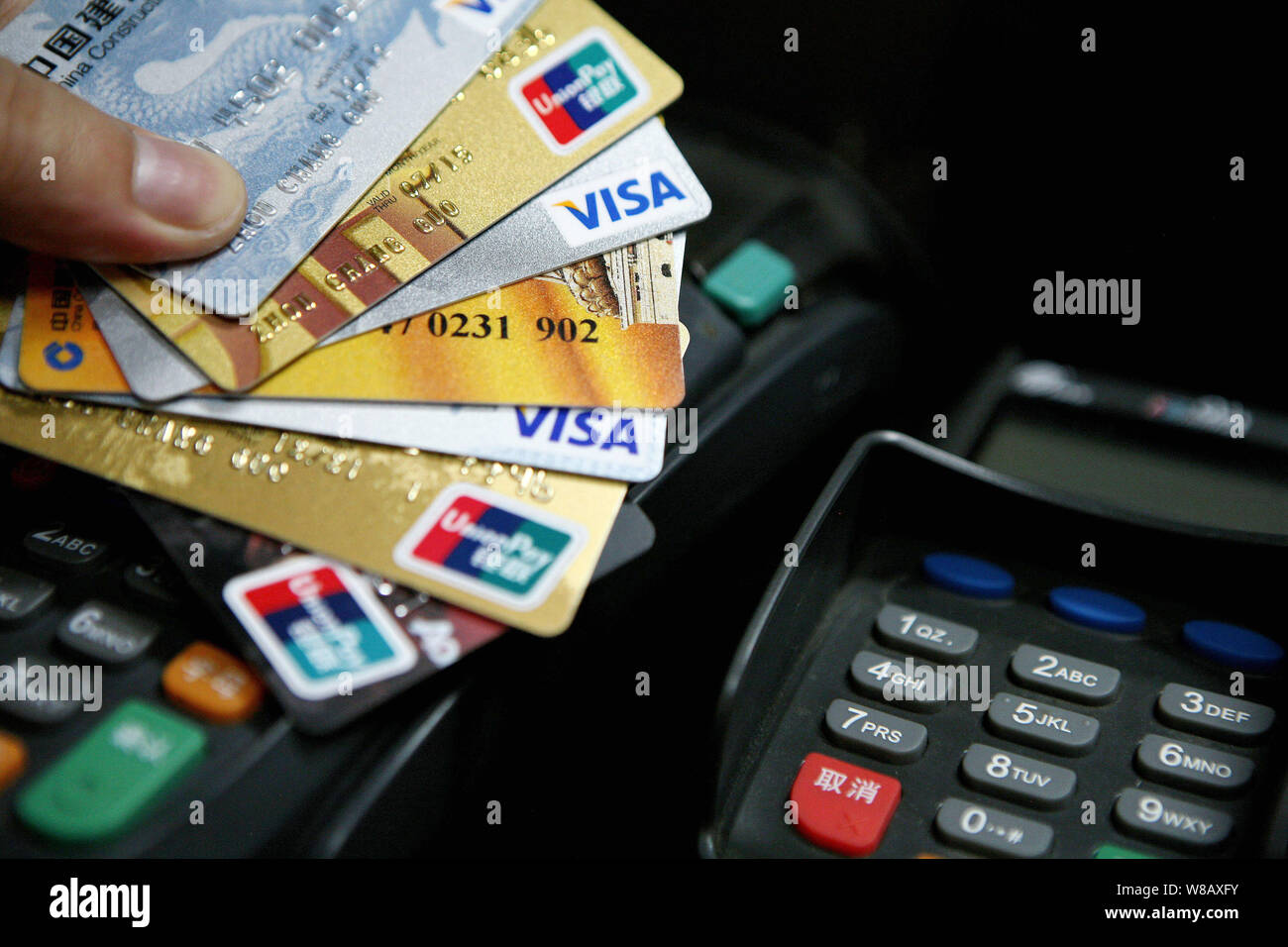--FILE--A Chinese resident shows his debit and credit cards supported ...