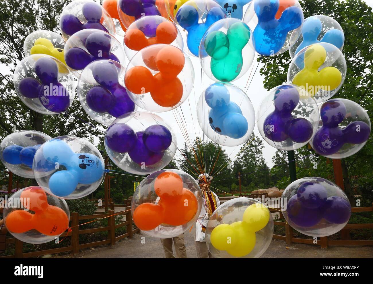 An employee shows Mickey Mouse balloons in the Shanghai Disneyland at ...