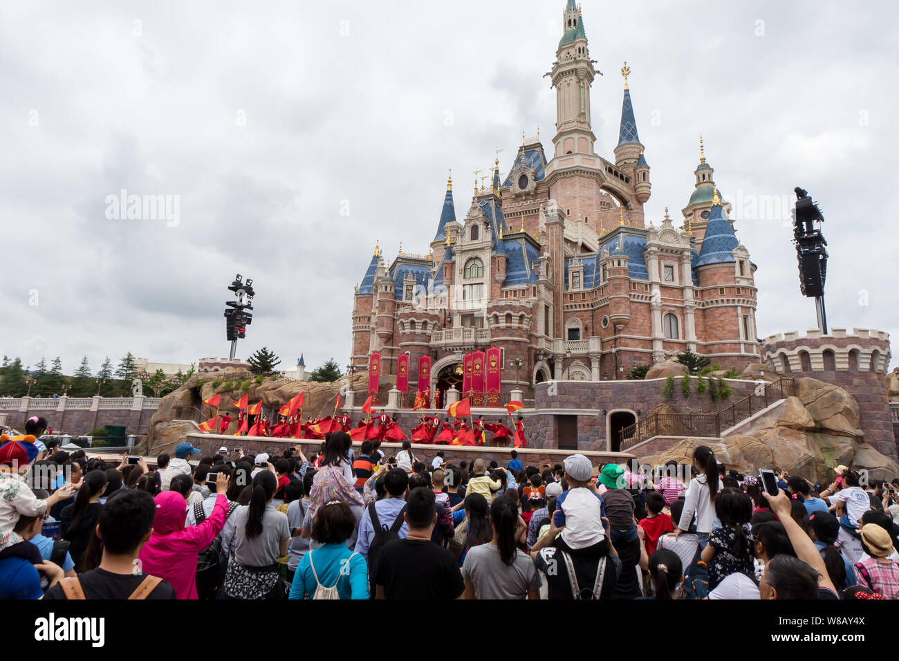 A crowd of tourists watch a performance at the Disney Castle in the ...
