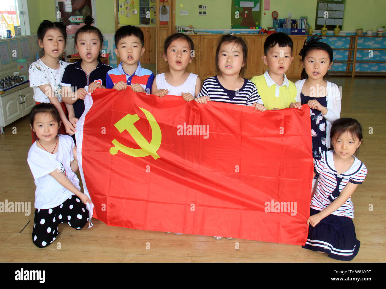Young Chinese kids display a flag of the Communist Party of China (CPC ...