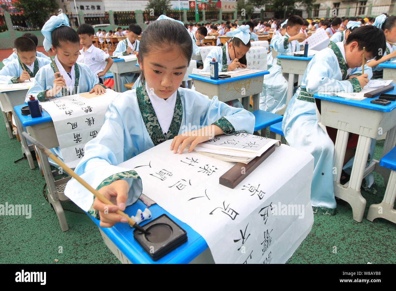 Young students calligraph Chinese characters during the opening ...