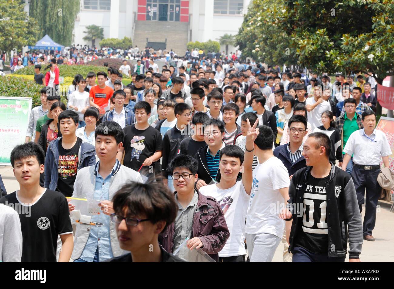 A crowd of Chinese students exit from a school after finishing an ...