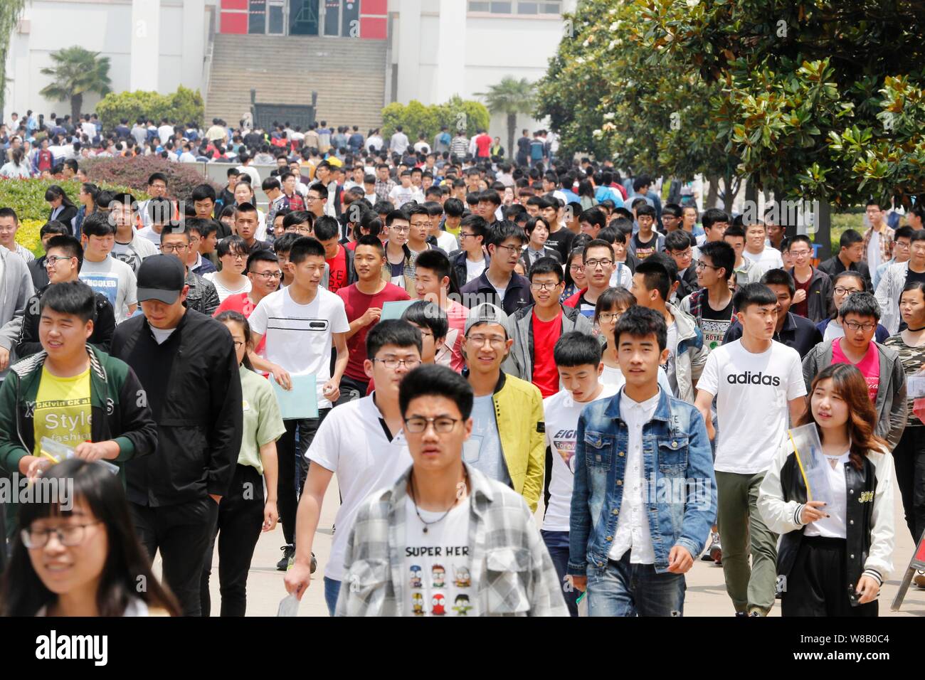 A crowd of Chinese students exit from a school after finishing an ...