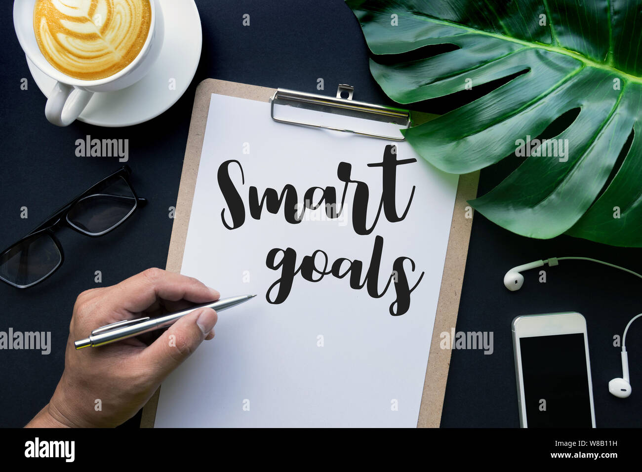 Smart goals text with hand writing on notepaper and accessories laying ...