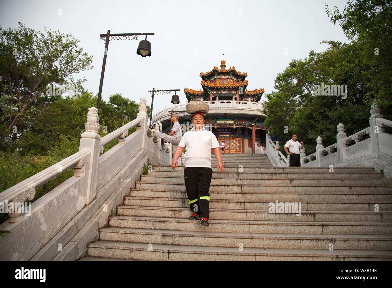 Chinese man Cong Yan walks with a cement block on his head during his ...