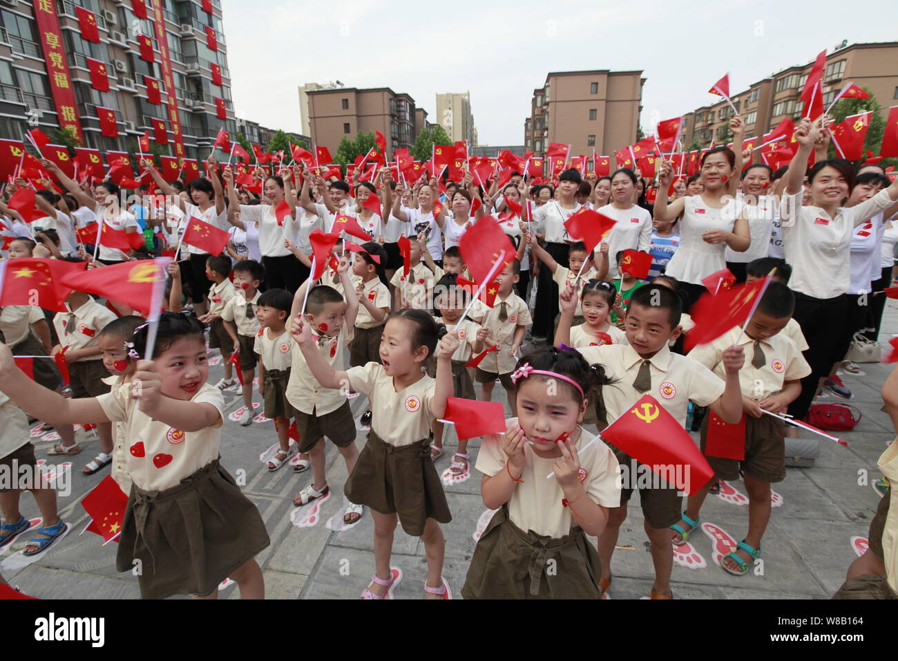 Young Chinese kids and local residents wave flags of China and the ...