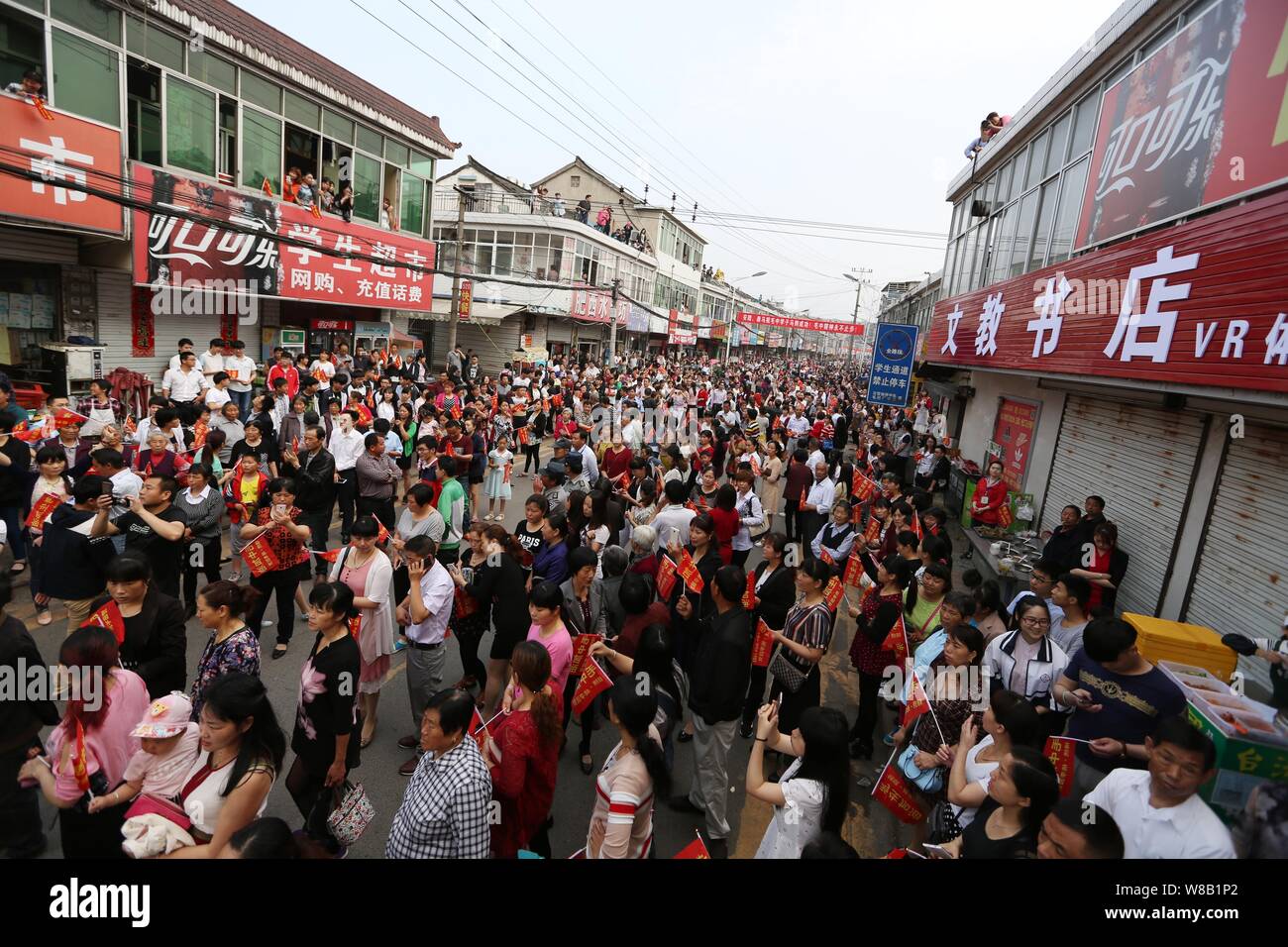 Chinese people crowd a road to wave goodbye to students of Maotanchang ...