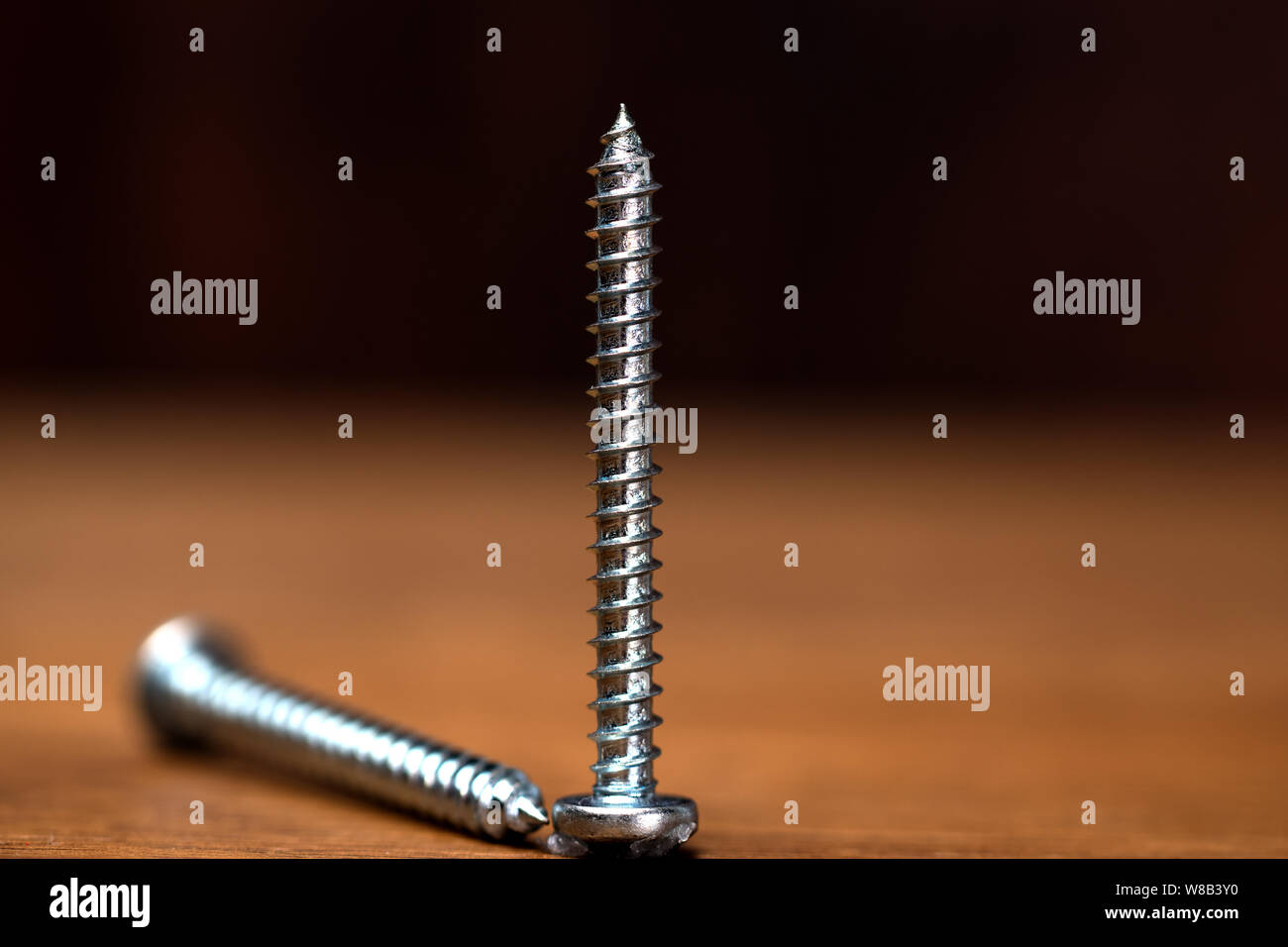 Long neck standing screws on wooden background hi-res stock photography ...