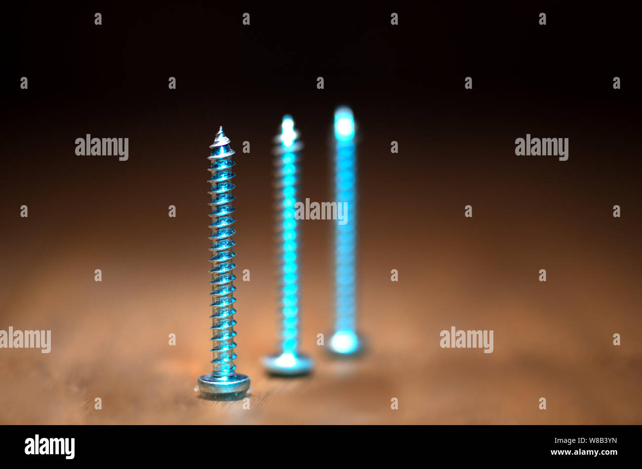 Long neck standing screws on wooden background hi-res stock photography ...