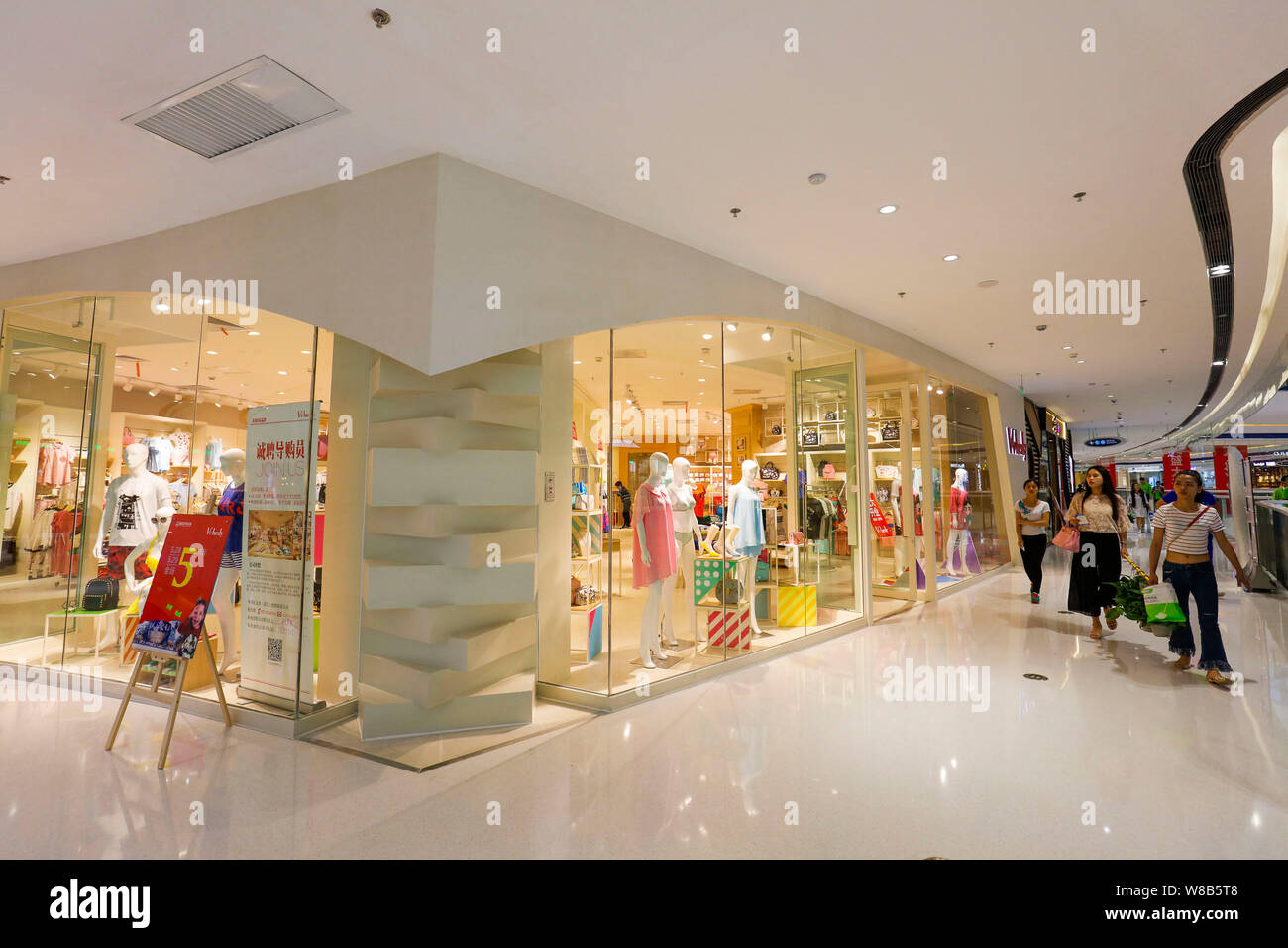 People walk past stores in the Wanda Mall at the Nanchang Wanda ...