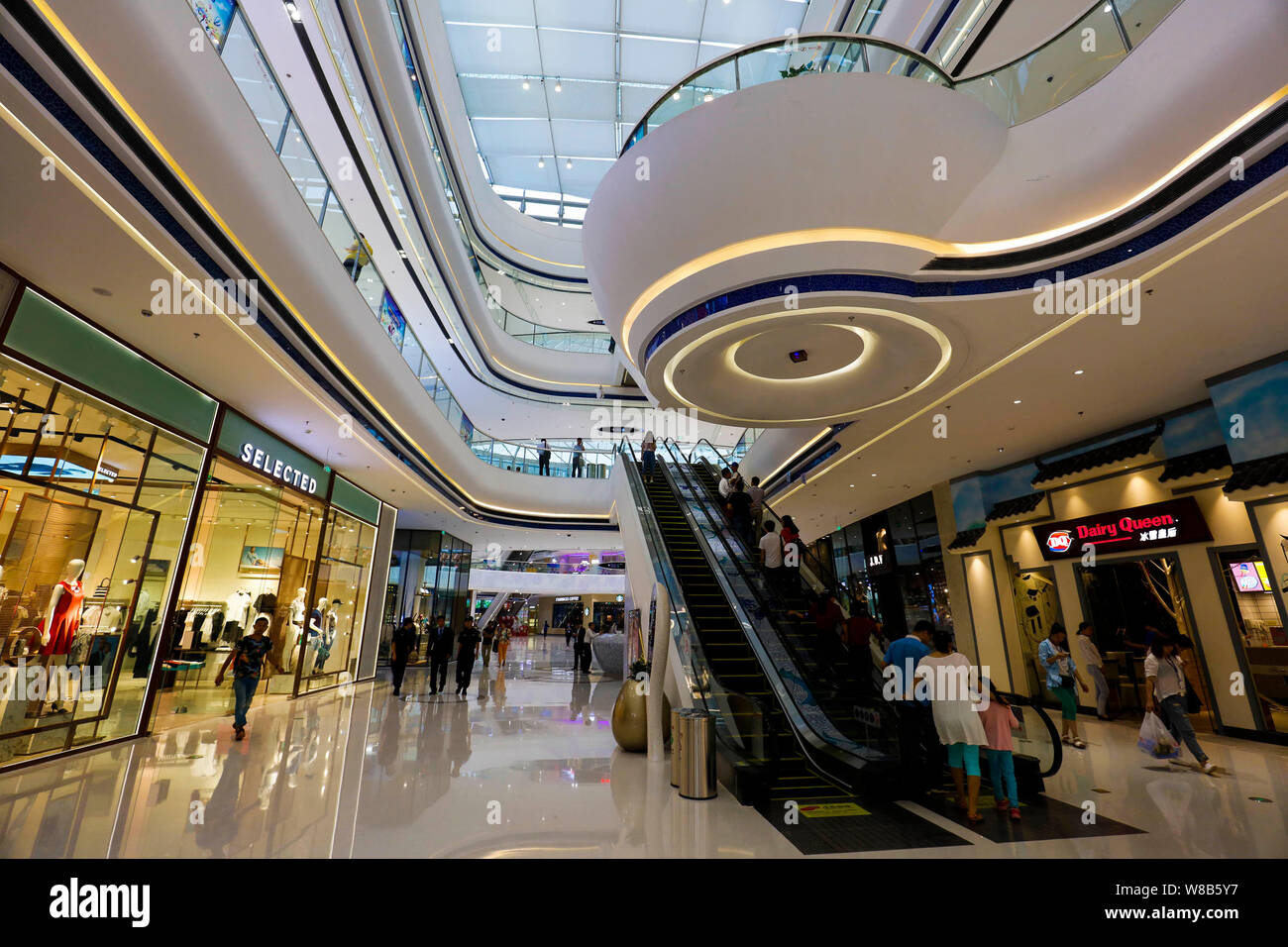 People walk past stores in the Wanda Mall at the Nanchang Wanda ...