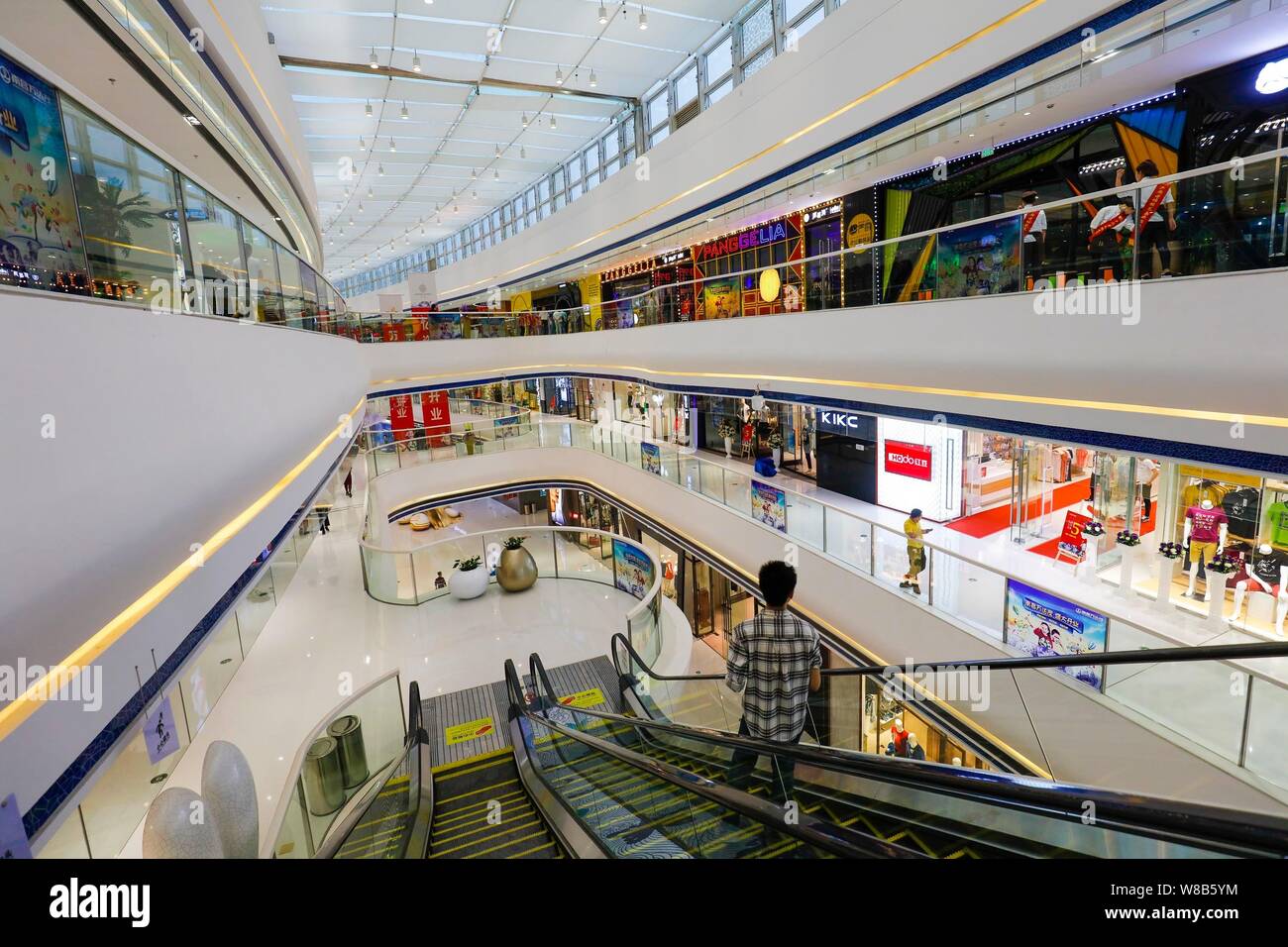 People walk past stores in the Wanda Mall at the Nanchang Wanda ...