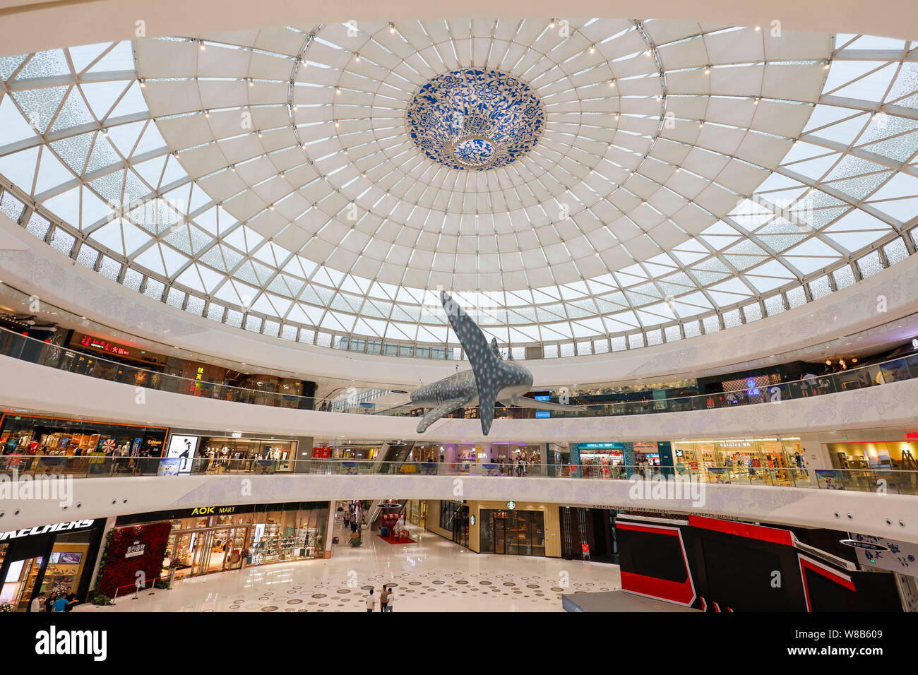 People walk past stores in the Wanda Mall at the Nanchang Wanda ...