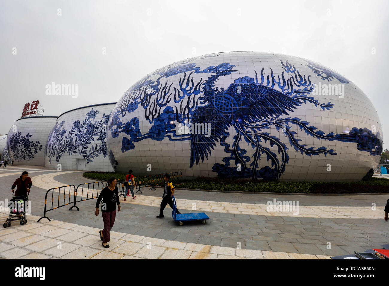 People walk past the Wanda Mall at the Nanchang Wanda Cultural Tourism ...