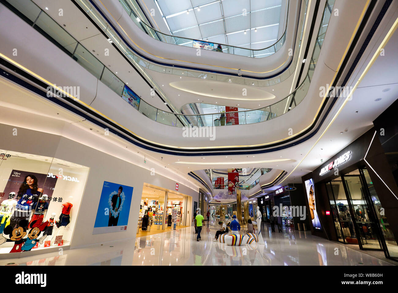 People walk past stores in the Wanda Mall at the Nanchang Wanda ...