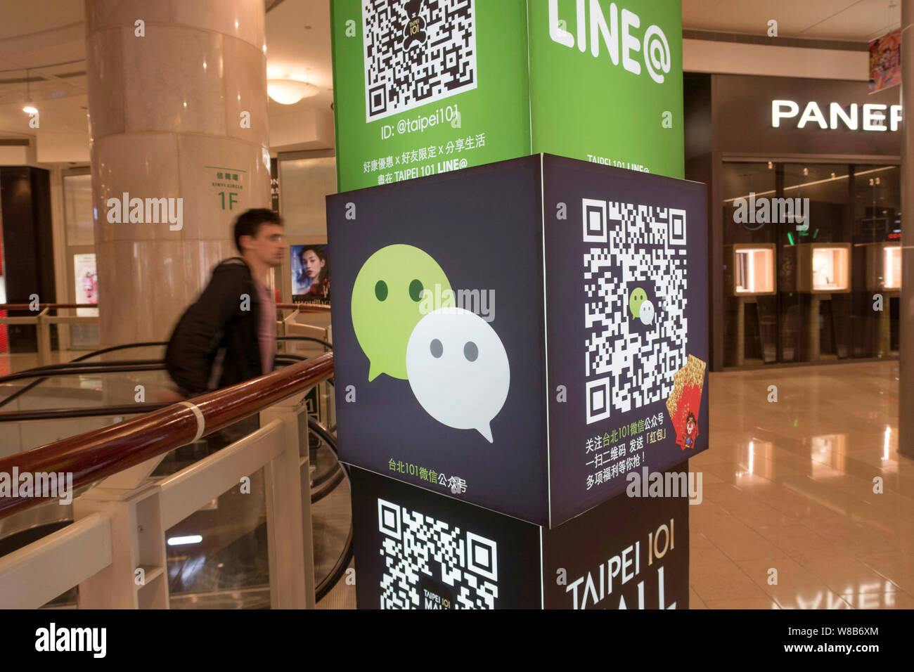 --FILE--A shopper walks past signages of Chinese mobile messaging app ...