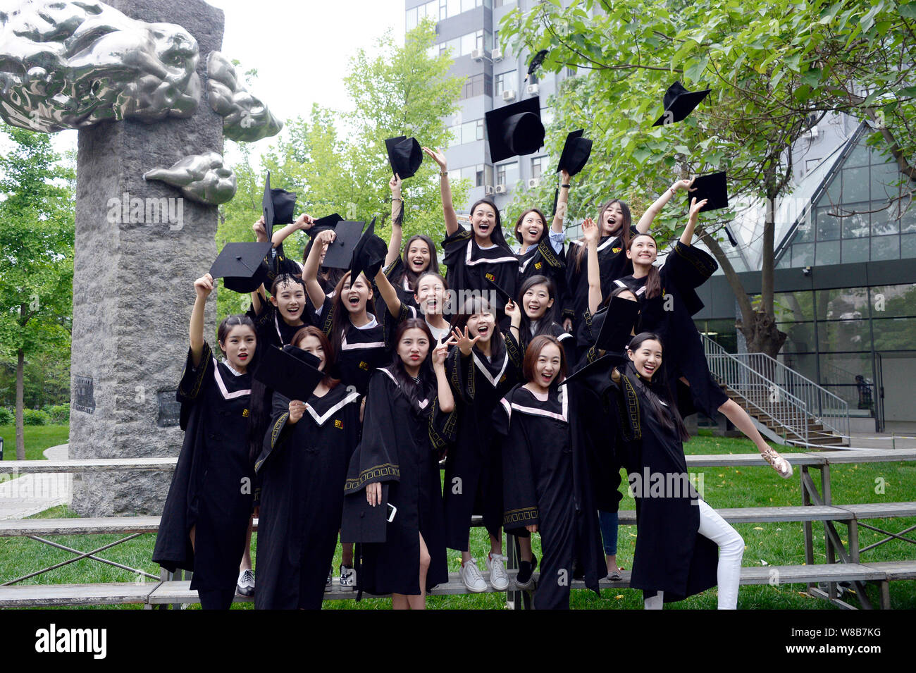Female Chinese graduates dressed in academic gowns pose during a ...