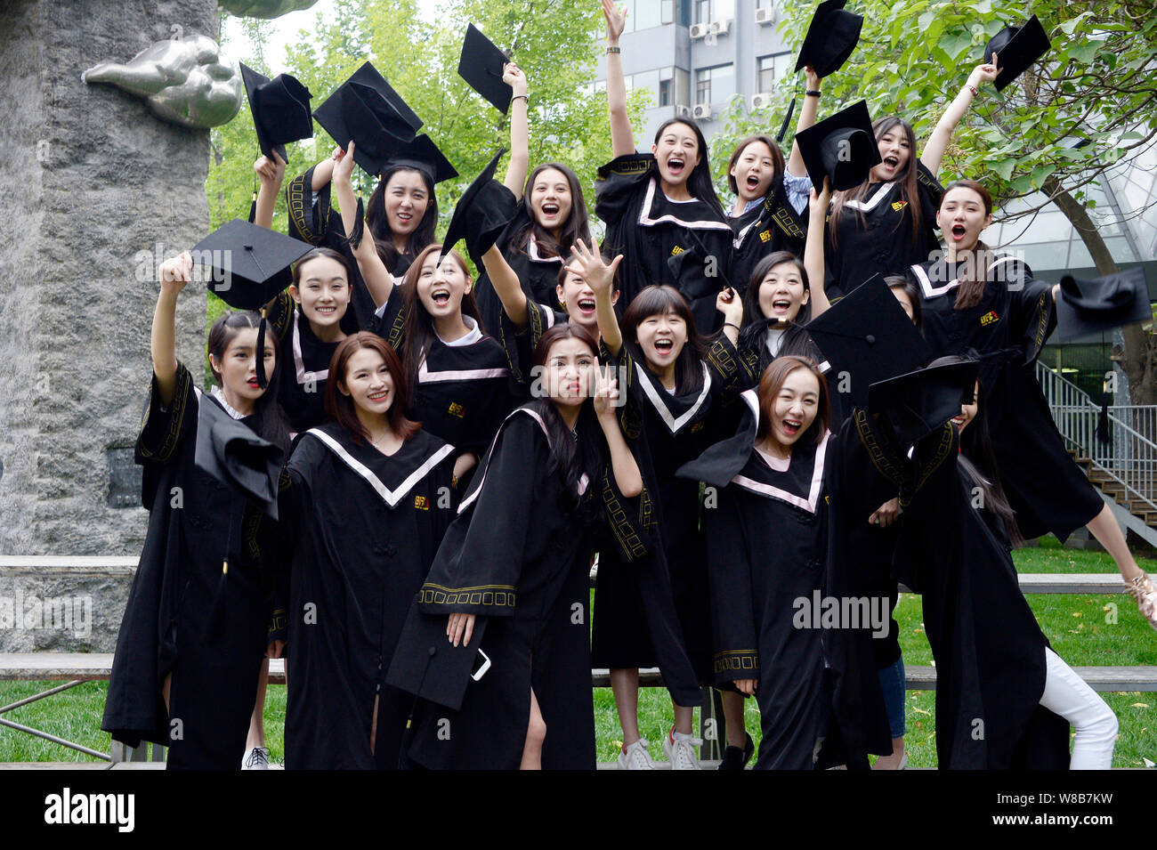Female Chinese graduates dressed in academic gowns pose during a ...