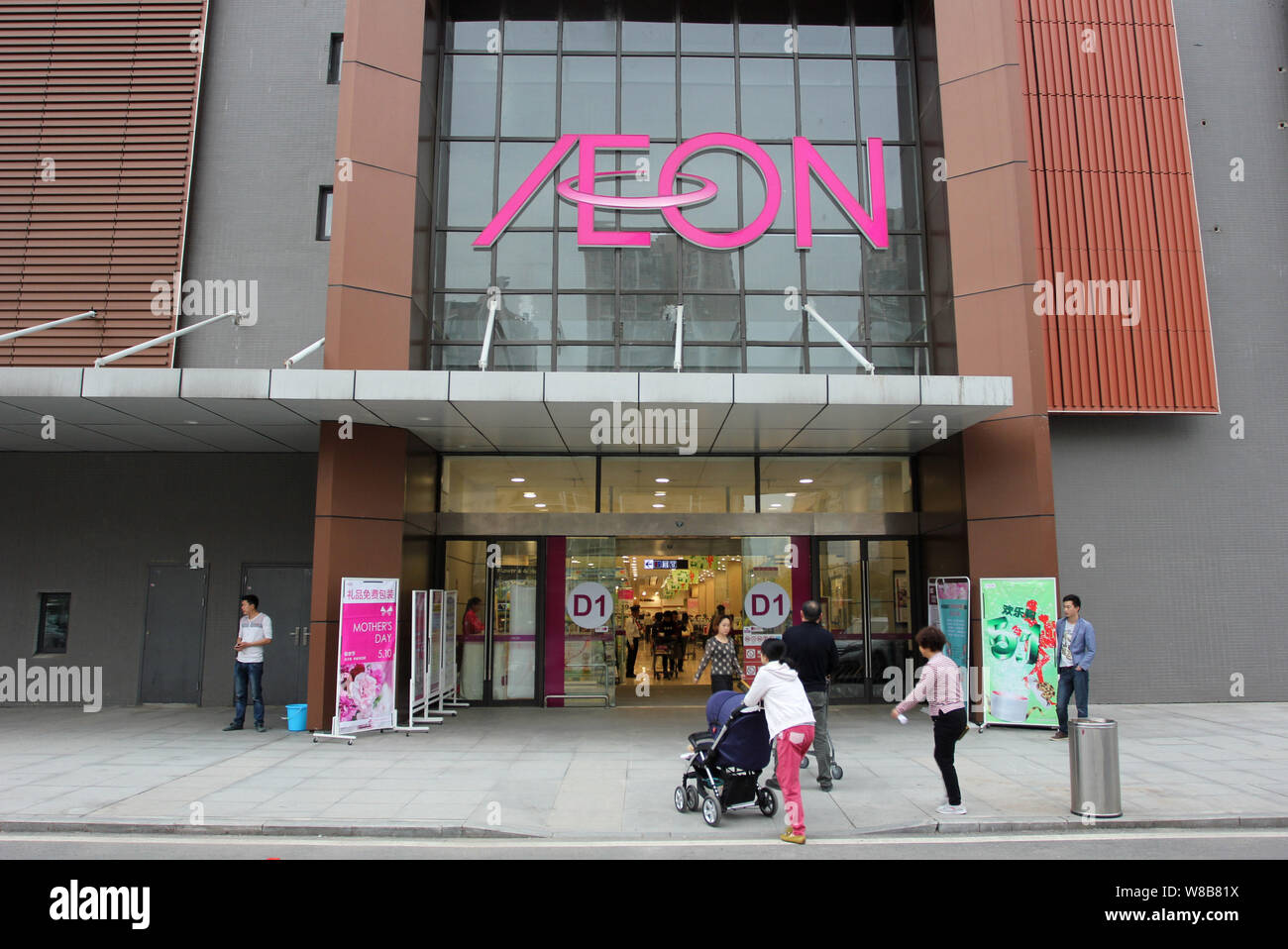 --FILE--Pedestrians walk past a shopping plaza of Aeon in Wuhan city ...
