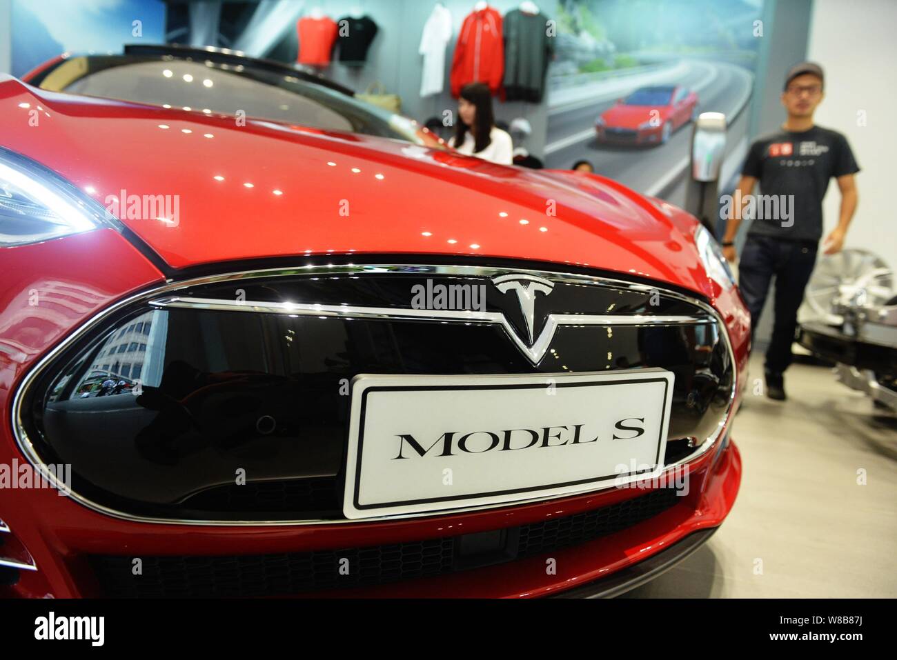 --FILE--Chinese car buyers look at a Tesla Model S electric car at a ...